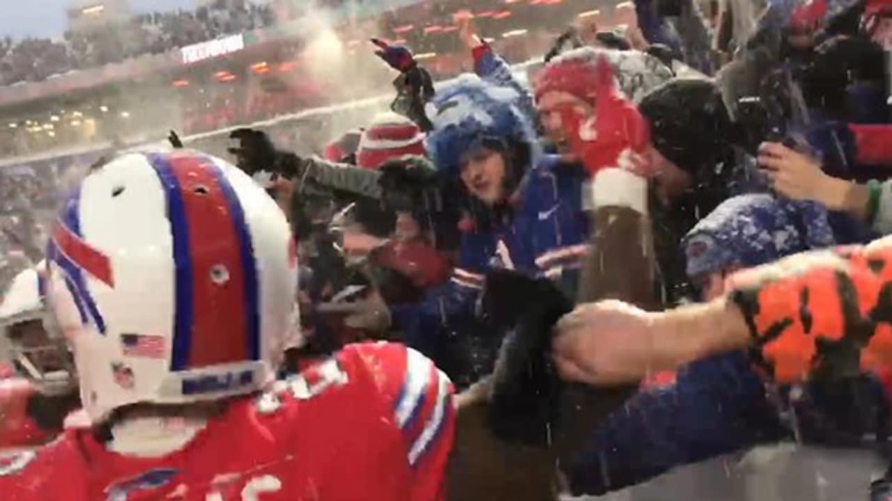 Buffalo Bills players celebrate the win in the snow with their fans