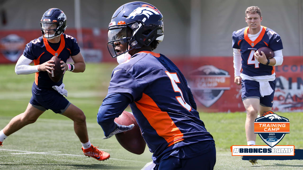 On the field with the quarterbacks for a pre-camp practice