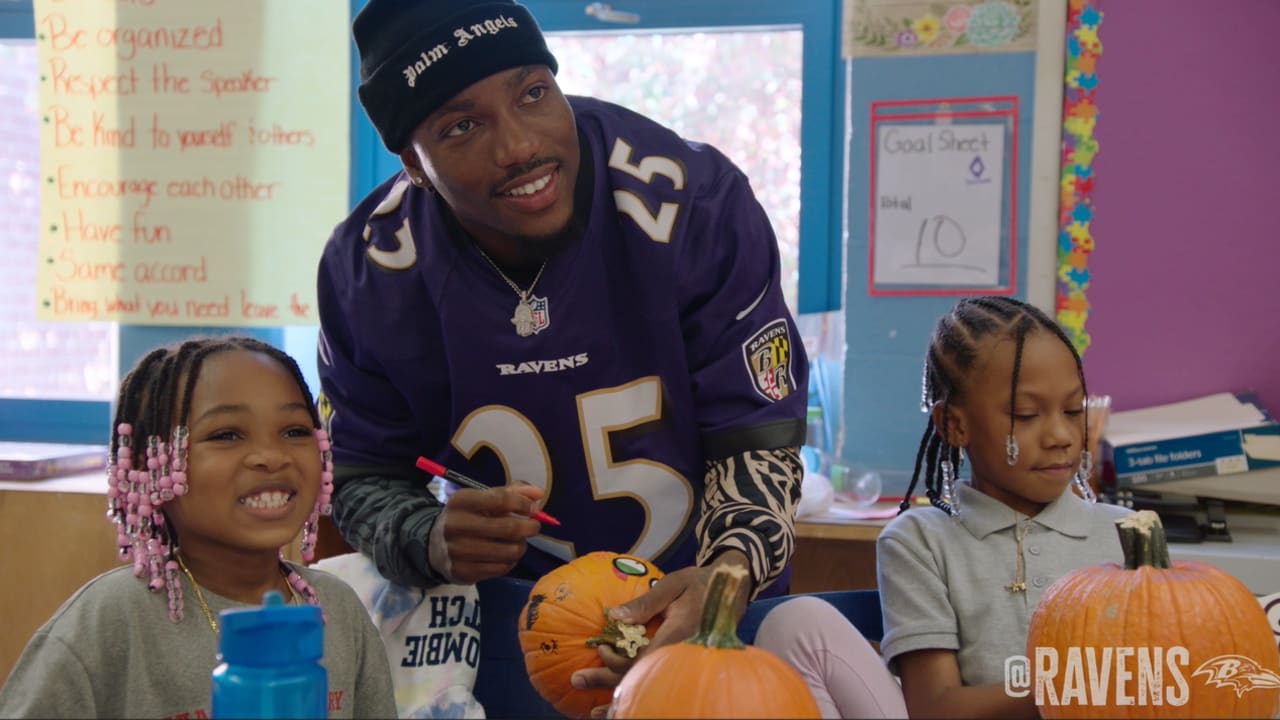 Ravens Decorate Pumpkins With Kids at School